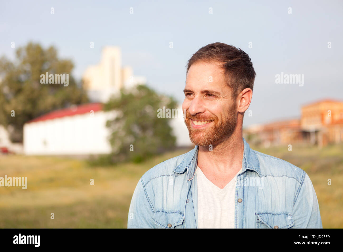Attractive happy guy with a town of background Stock Photo - Alamy