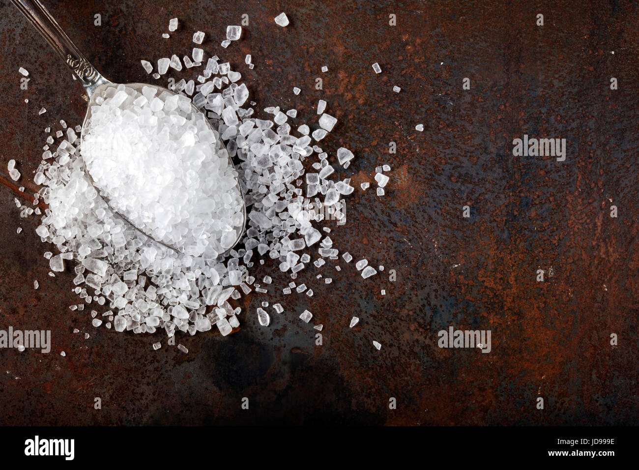 Sea salt in stainless steel spoon over rusty background Stock Photo - Alamy