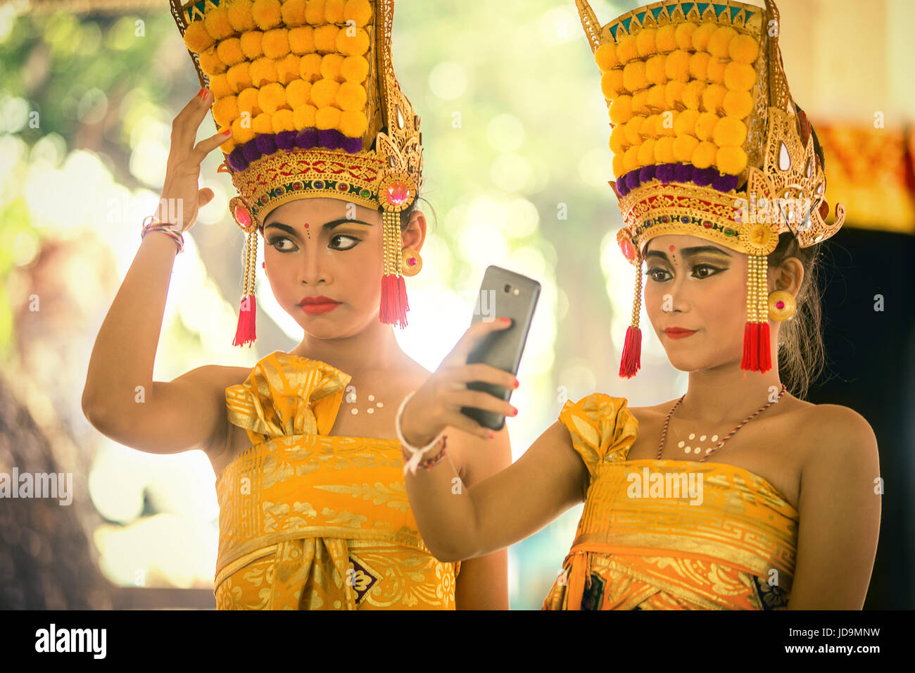 Pair of young Balinese girls dressed in beautiful Balinese costume take ...