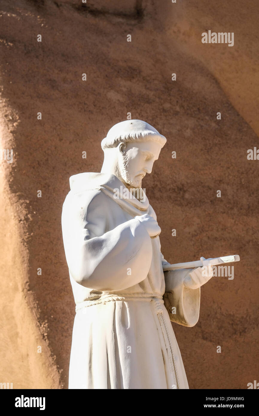 A stone statue of a priest in front of a church in New Mexico, United ...