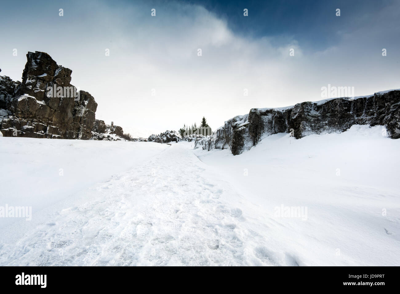 Deep snow covered pathway with footprints by rock formations, Iceland ...