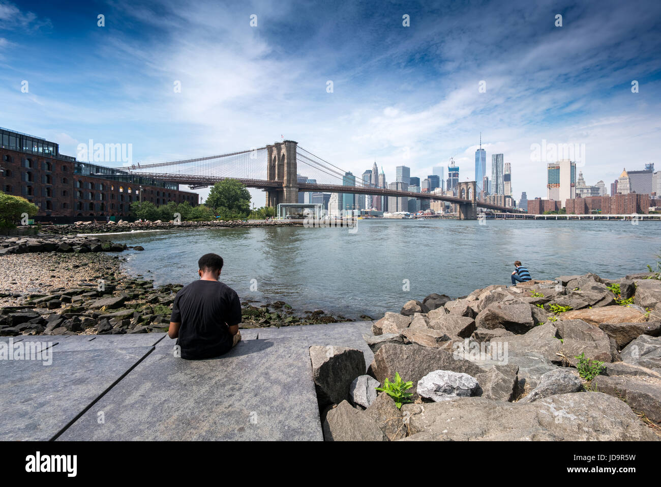 Man sitting with Brooklyn Bridge in distance, New York City, USA. 2016 ...