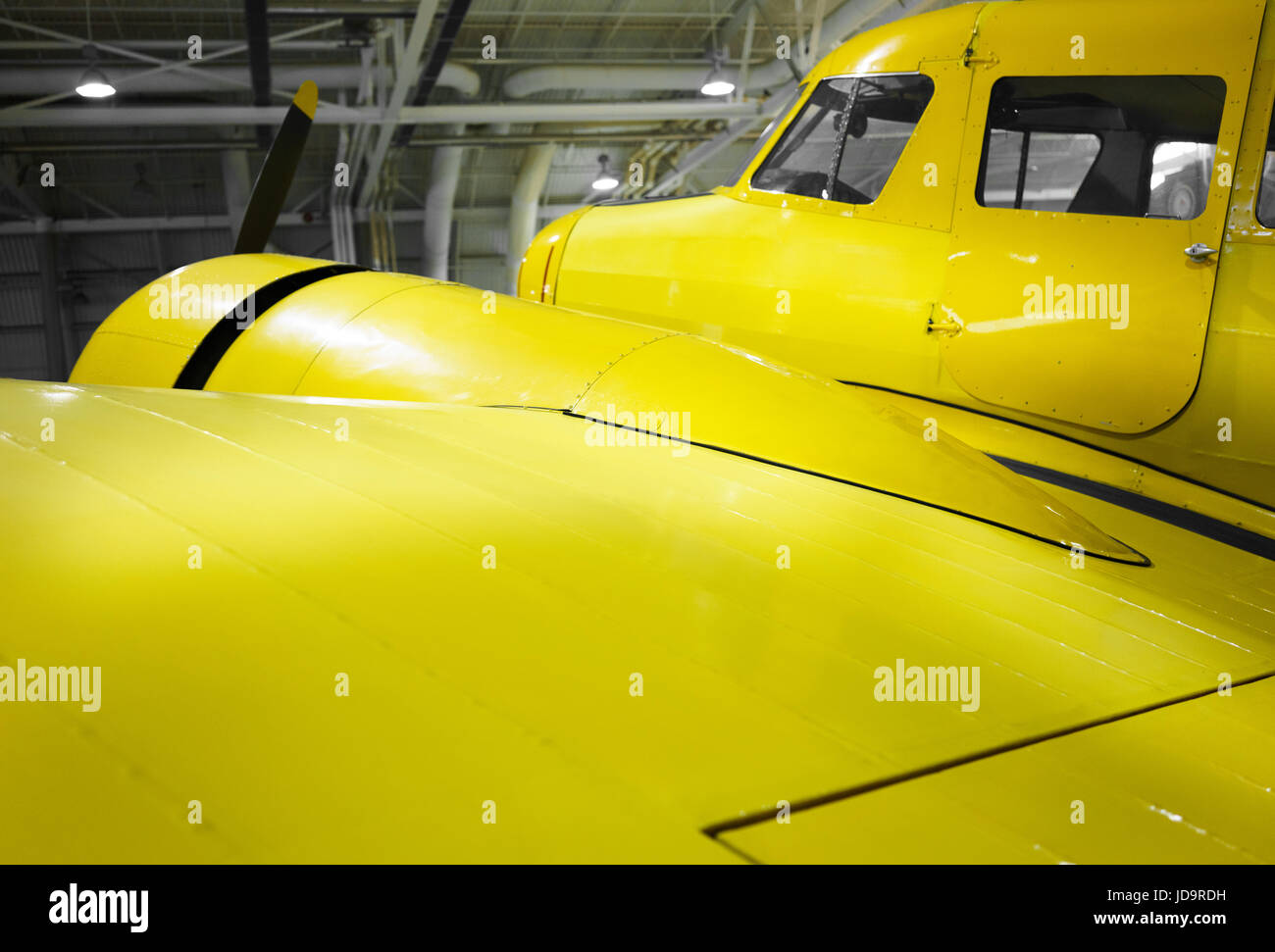 Part of and close up of yellow painted, stationary, propeller plane ...