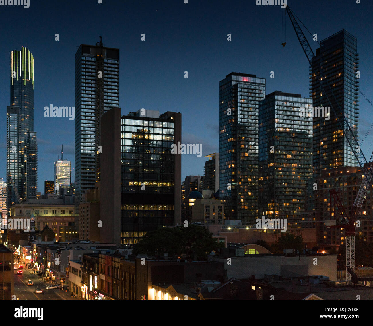 Cityscape at dusk, modern skyscrapers with illuminated windows and ...