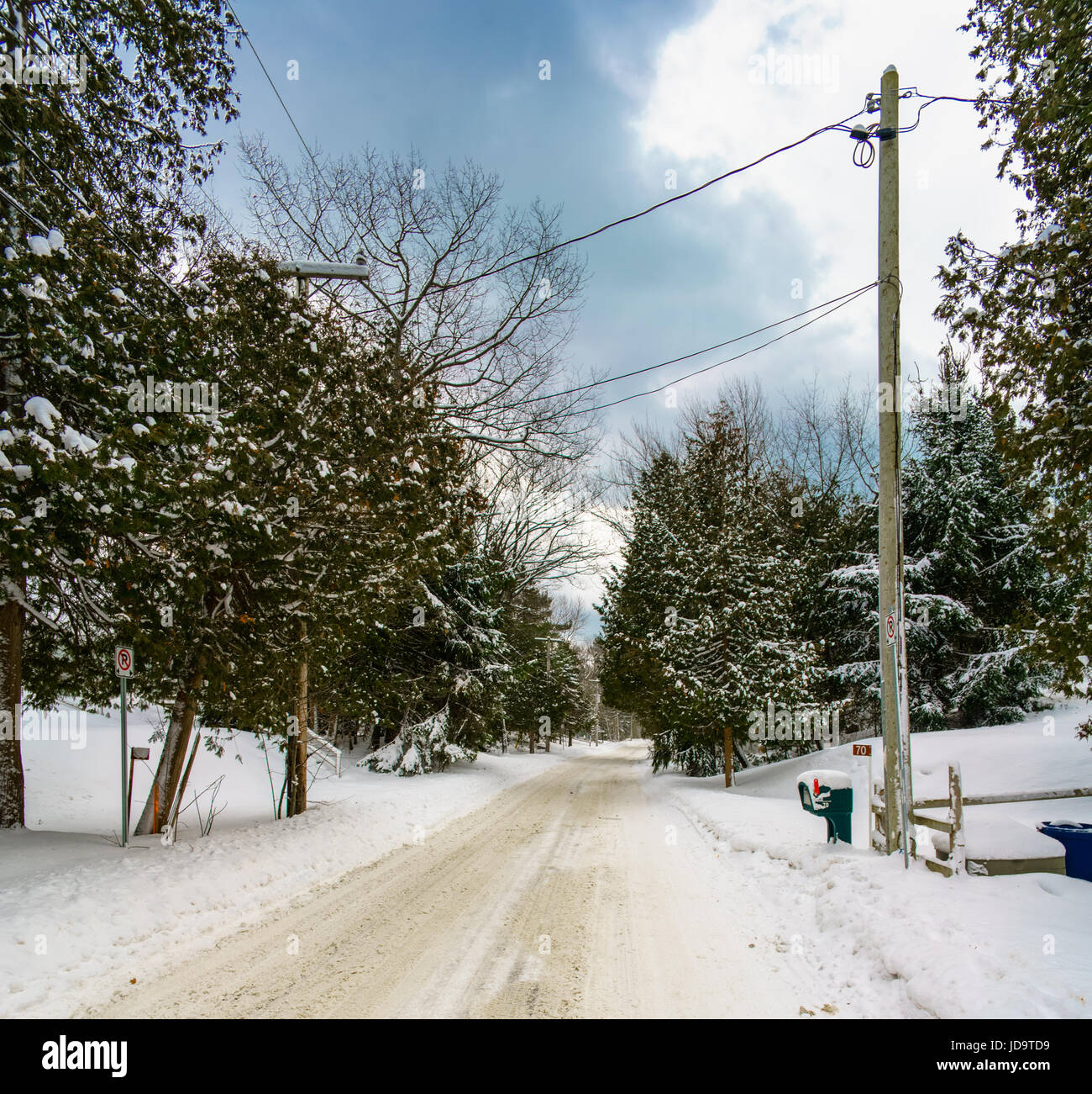 Rural, snow covered road with telegraph pole and cables in foreground ...