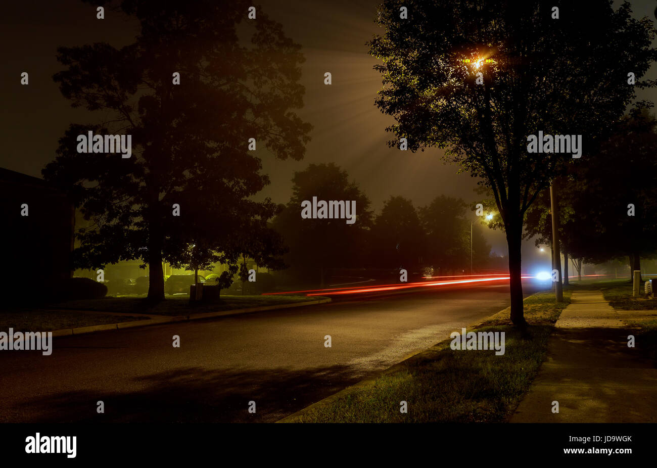 The residential block on an empty night street covered with fog ...