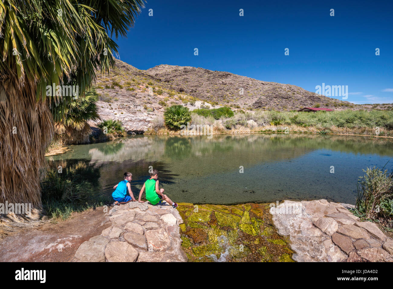 Young boys at pond at Rogers Spring, geothermal hot spring oasis near ...