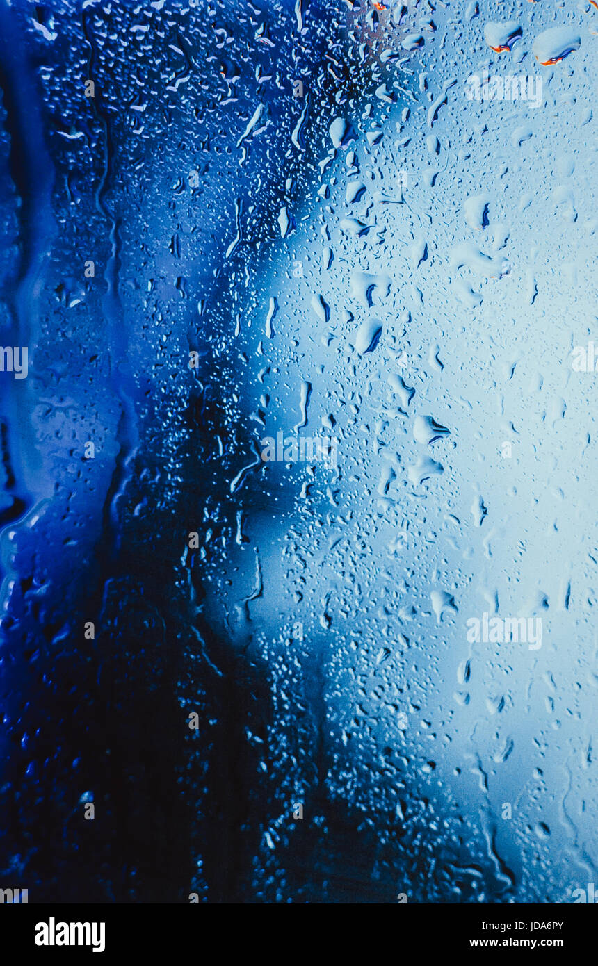 Drops on the glass rain blue background Stock Photo - Alamy