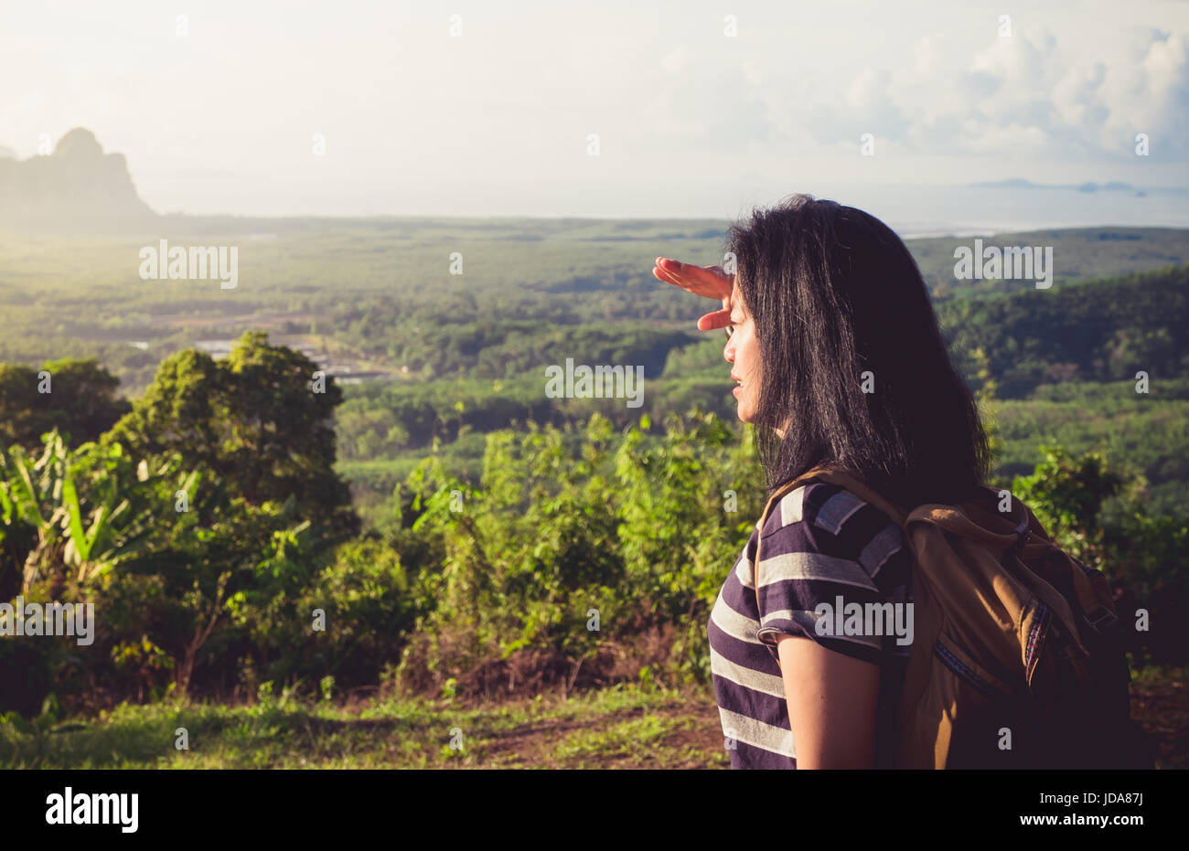 young traveler backpacker looking forward at sun to see landscape view ...