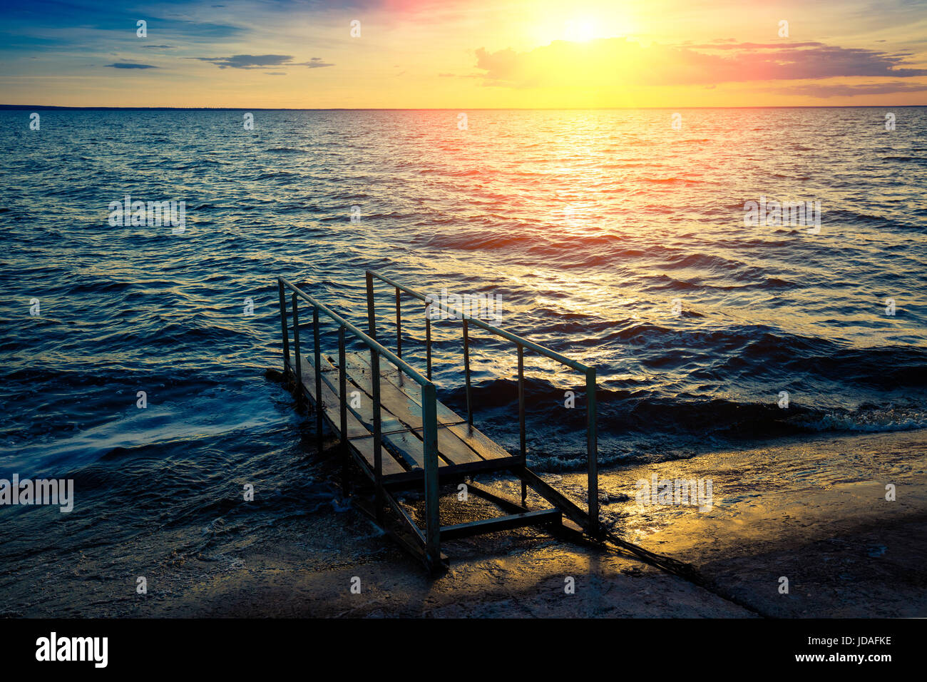 Evening on the beach, sunset over sea, pier on the sea Stock Photo - Alamy