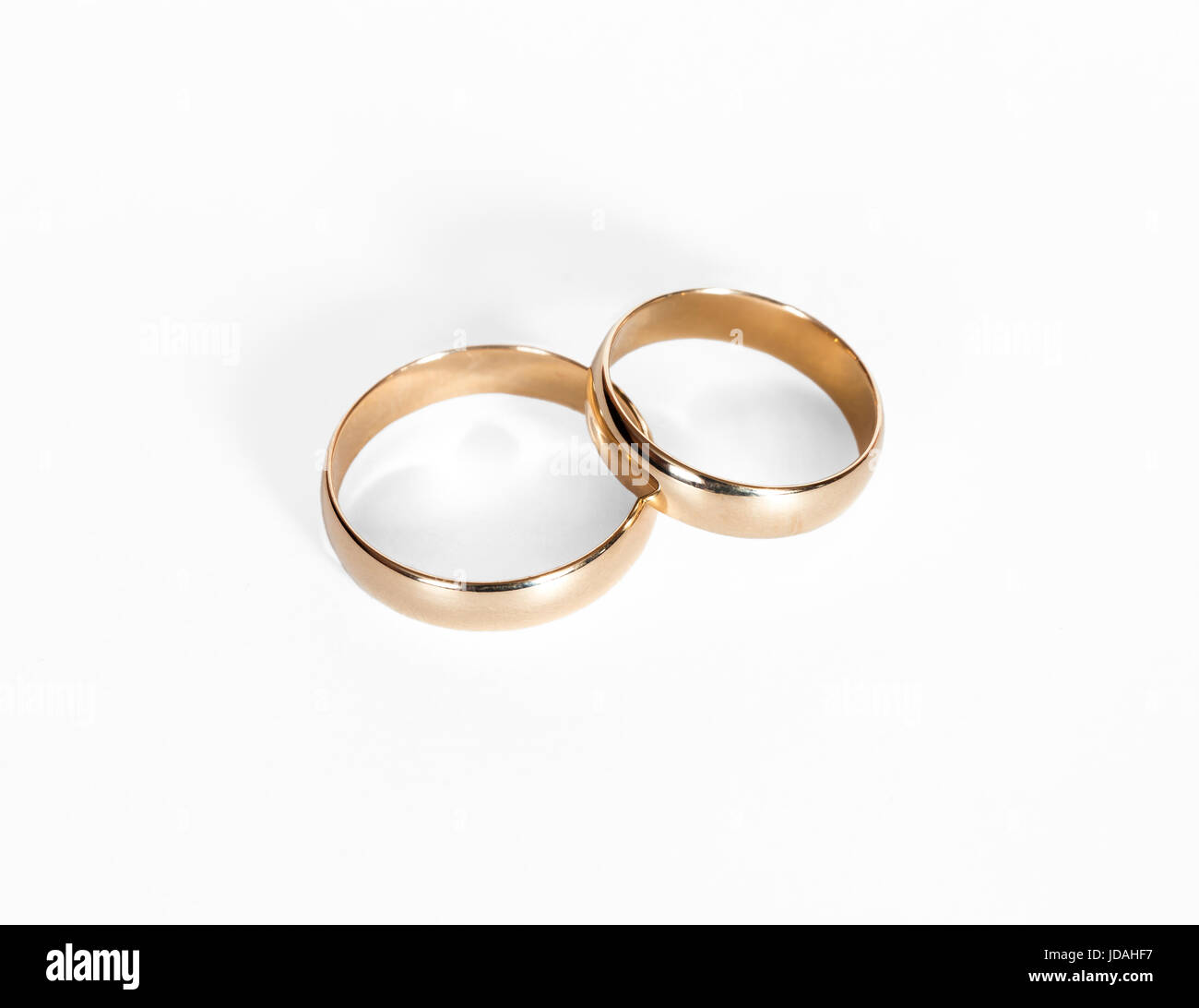Two gold wedding rings close up on a white background Stock Photo - Alamy