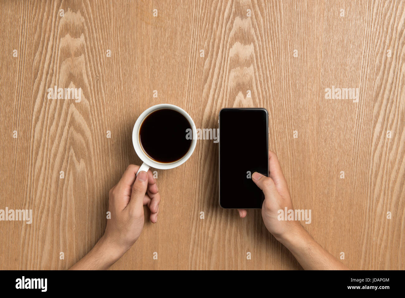 Man using smart phone sitting on table, hand holding smart phone ...