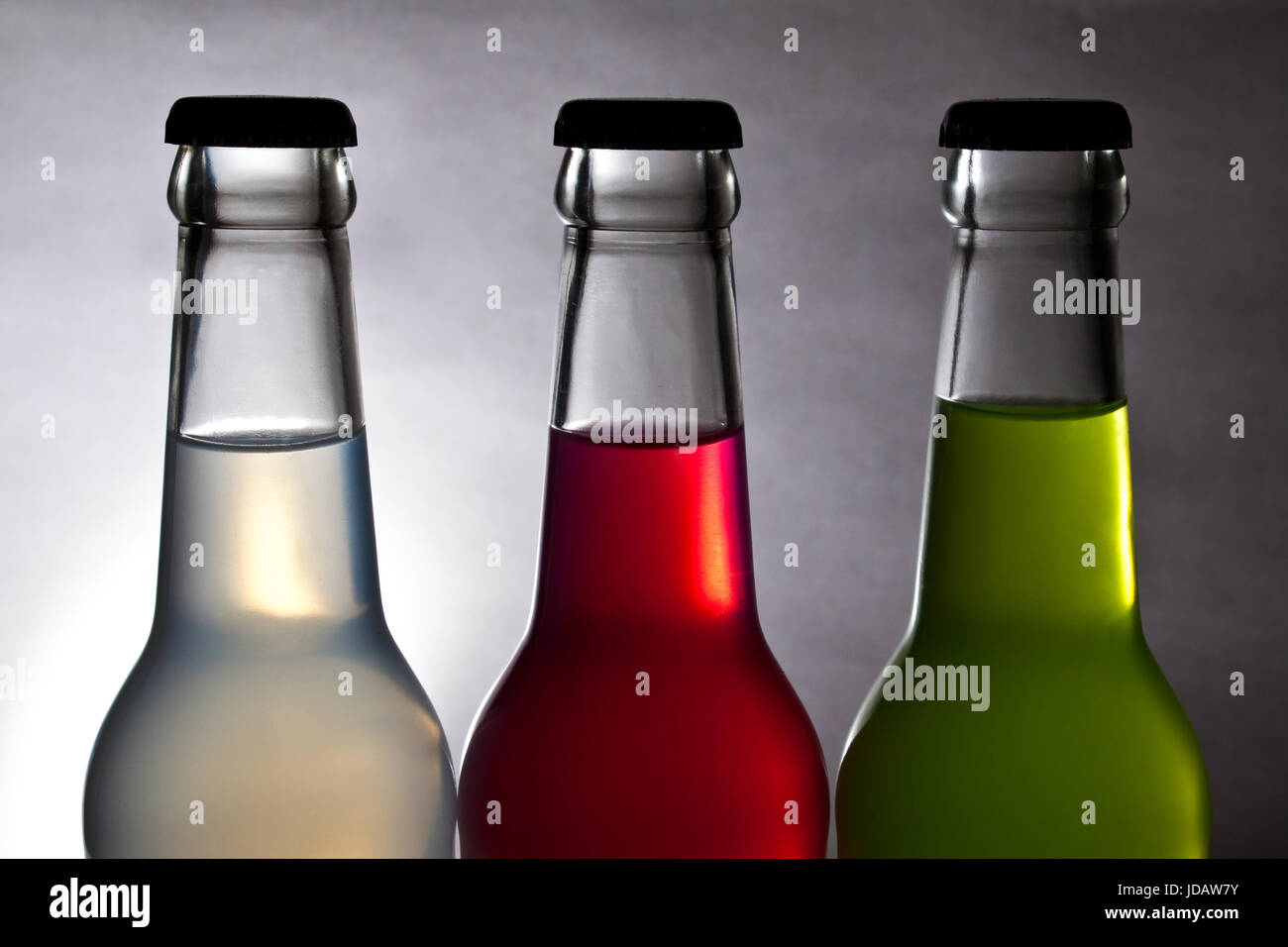 three colorful bottle of drink on light background Stock Photo - Alamy