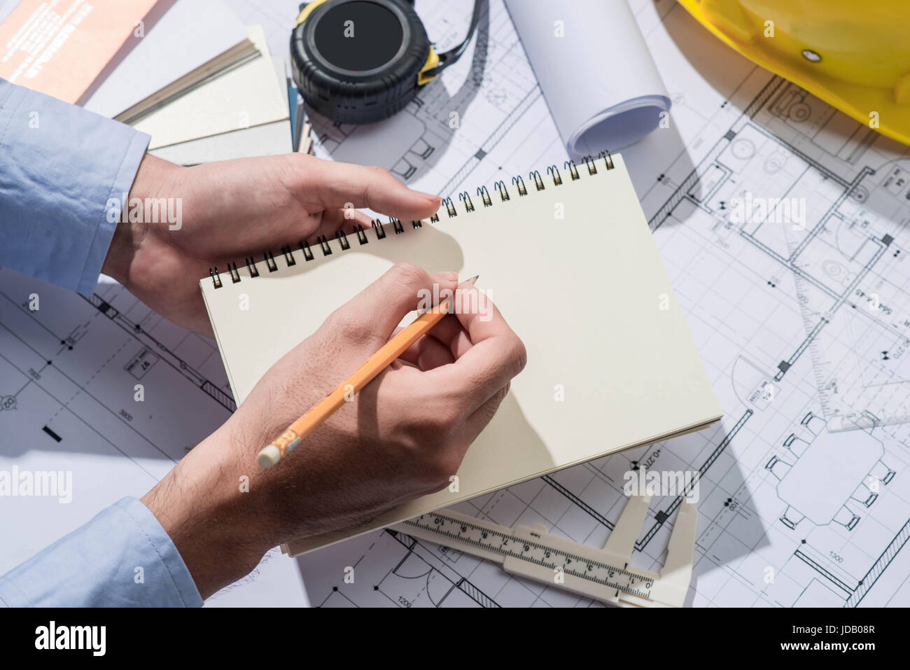 Working on blueprints. Construction project with hands writing on ...