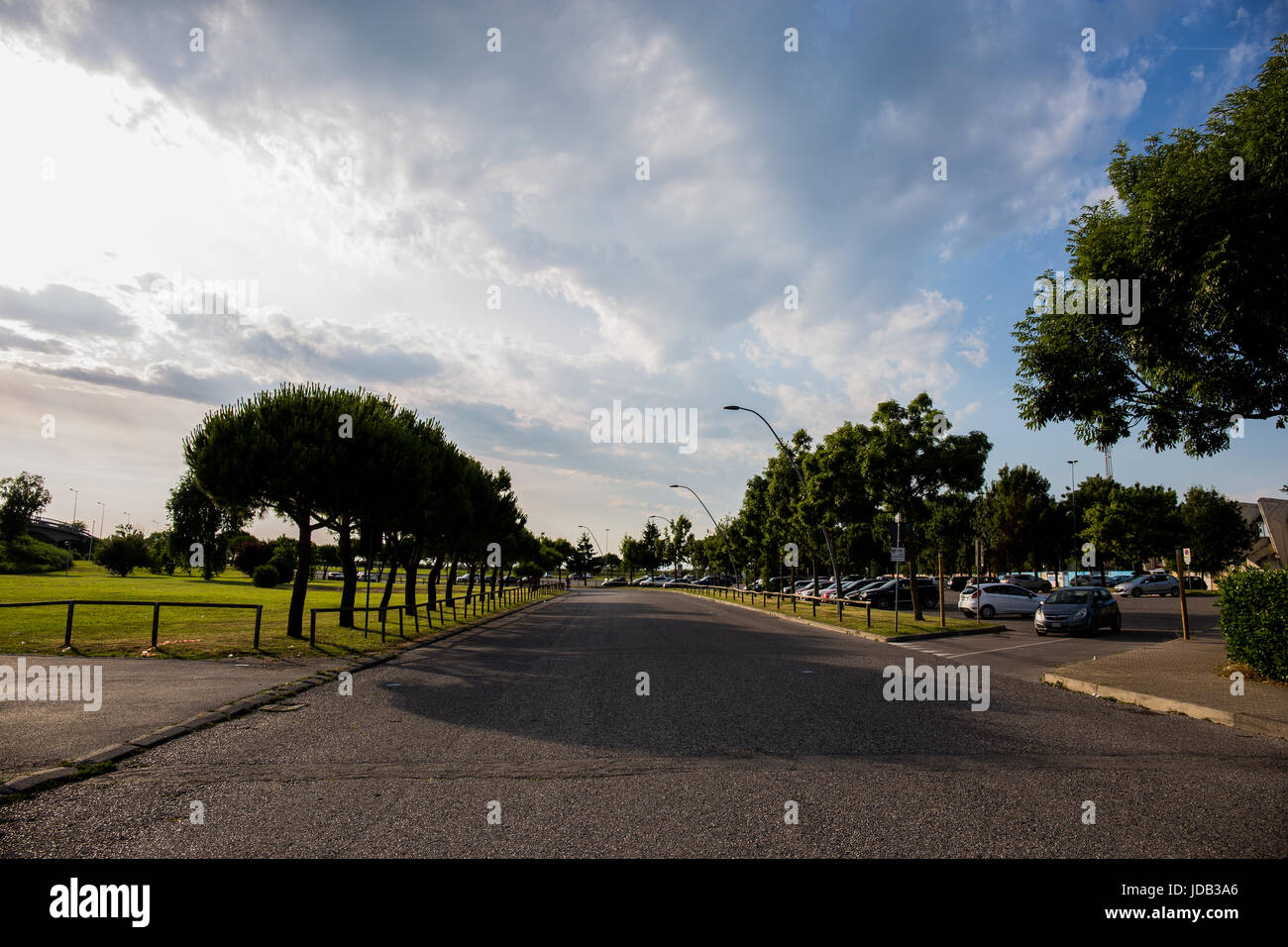 Very large asphalt road with big parking nearby Stock Photo - Alamy