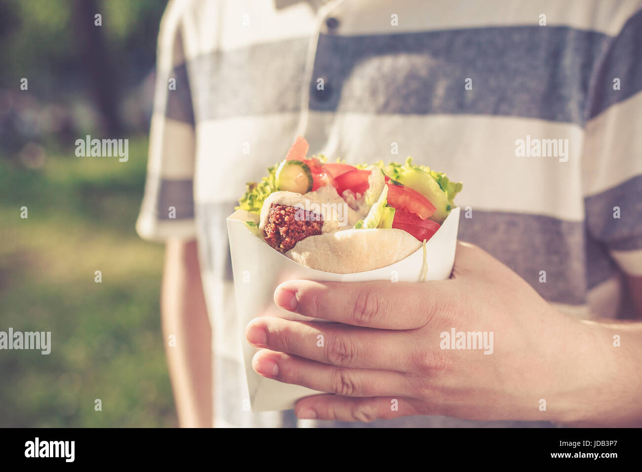 Man is holding falafel sandwich in paper bag. Healthy street food ...