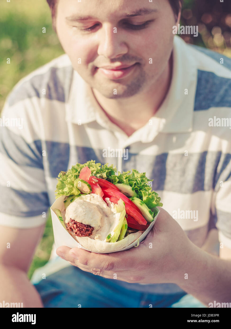 Man is holding falafel sandwich in paper bag. Healthy street food ...