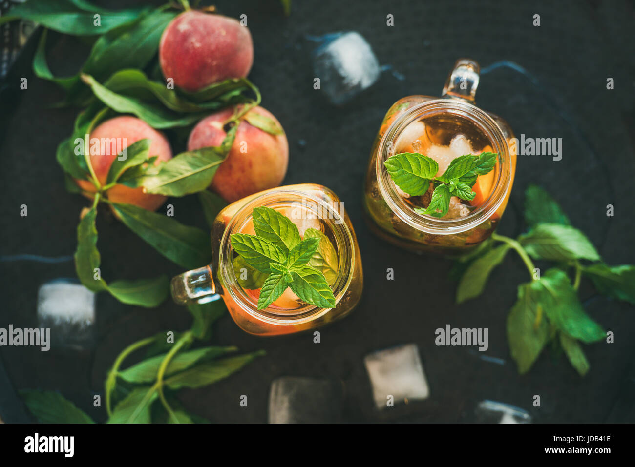 Summer refreshing cold peach ice tea in glass jars Stock Photo - Alamy