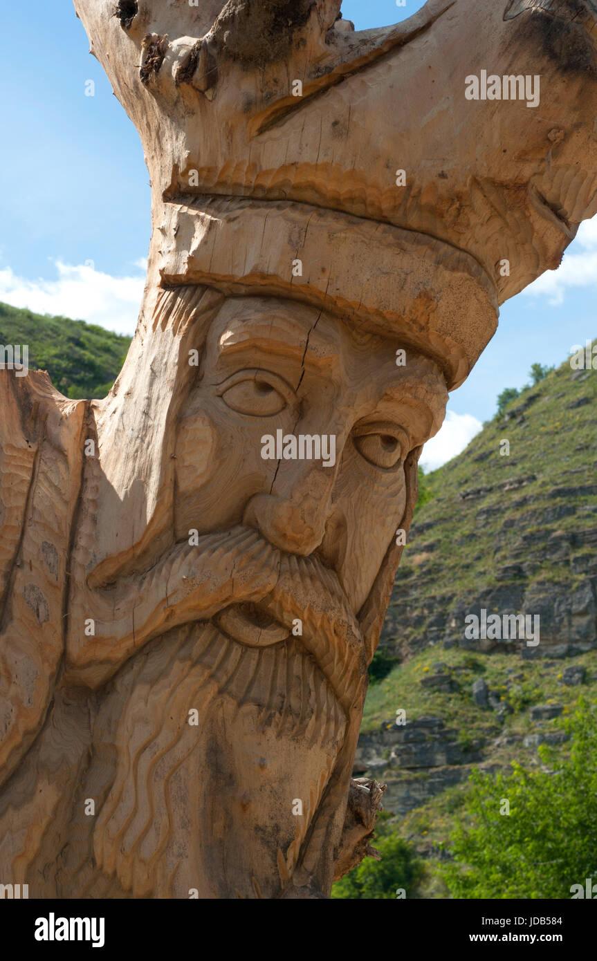 Wooden statue from tree. An old man's face statue Stock Photo - Alamy