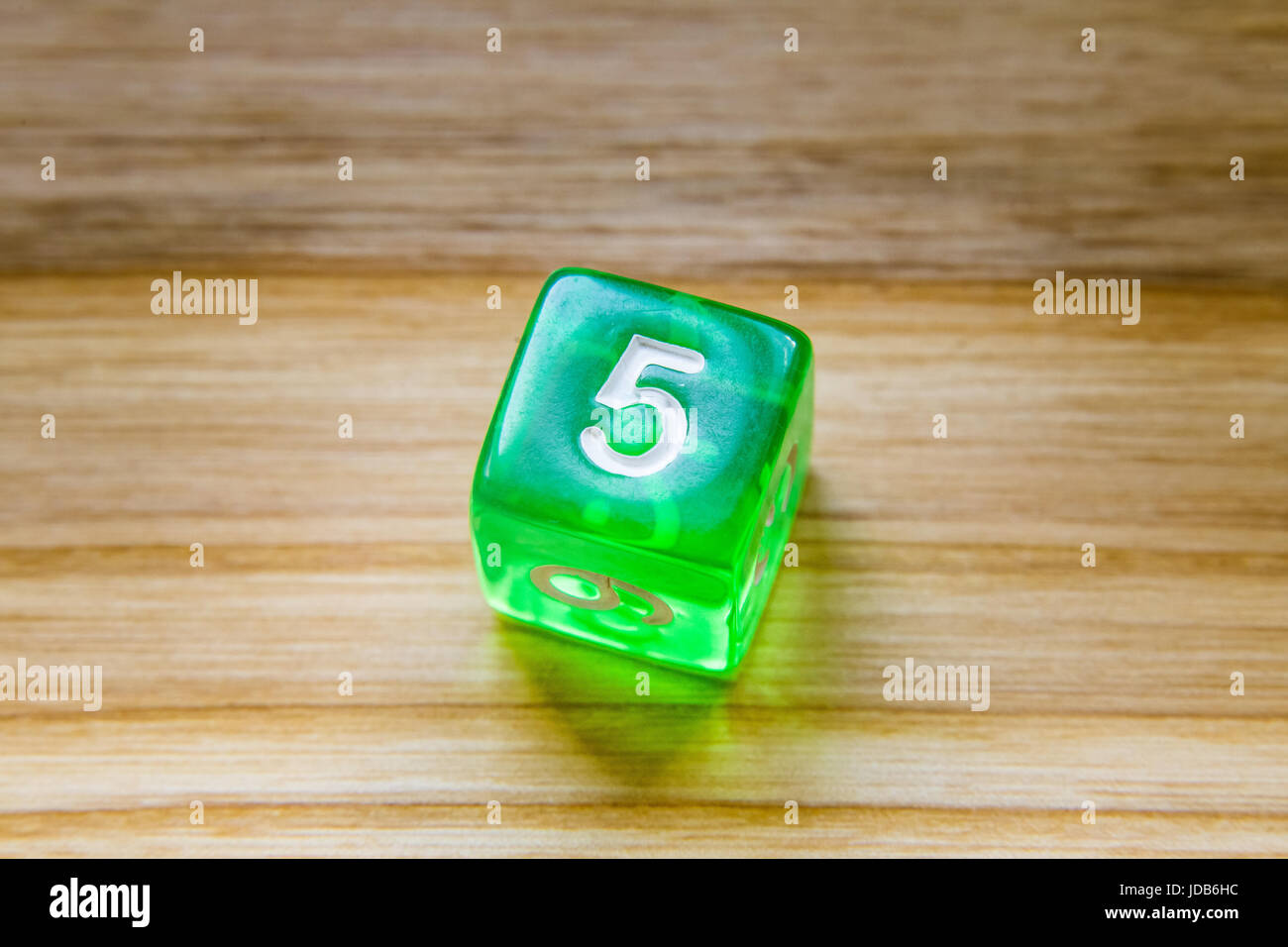 A beautiful winning playing dice rolled on a side on wooden table Stock ...