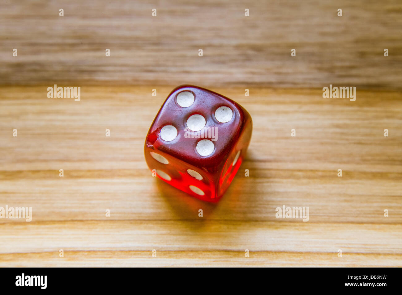 A beautiful winning playing dice rolled on a side on wooden table Stock ...
