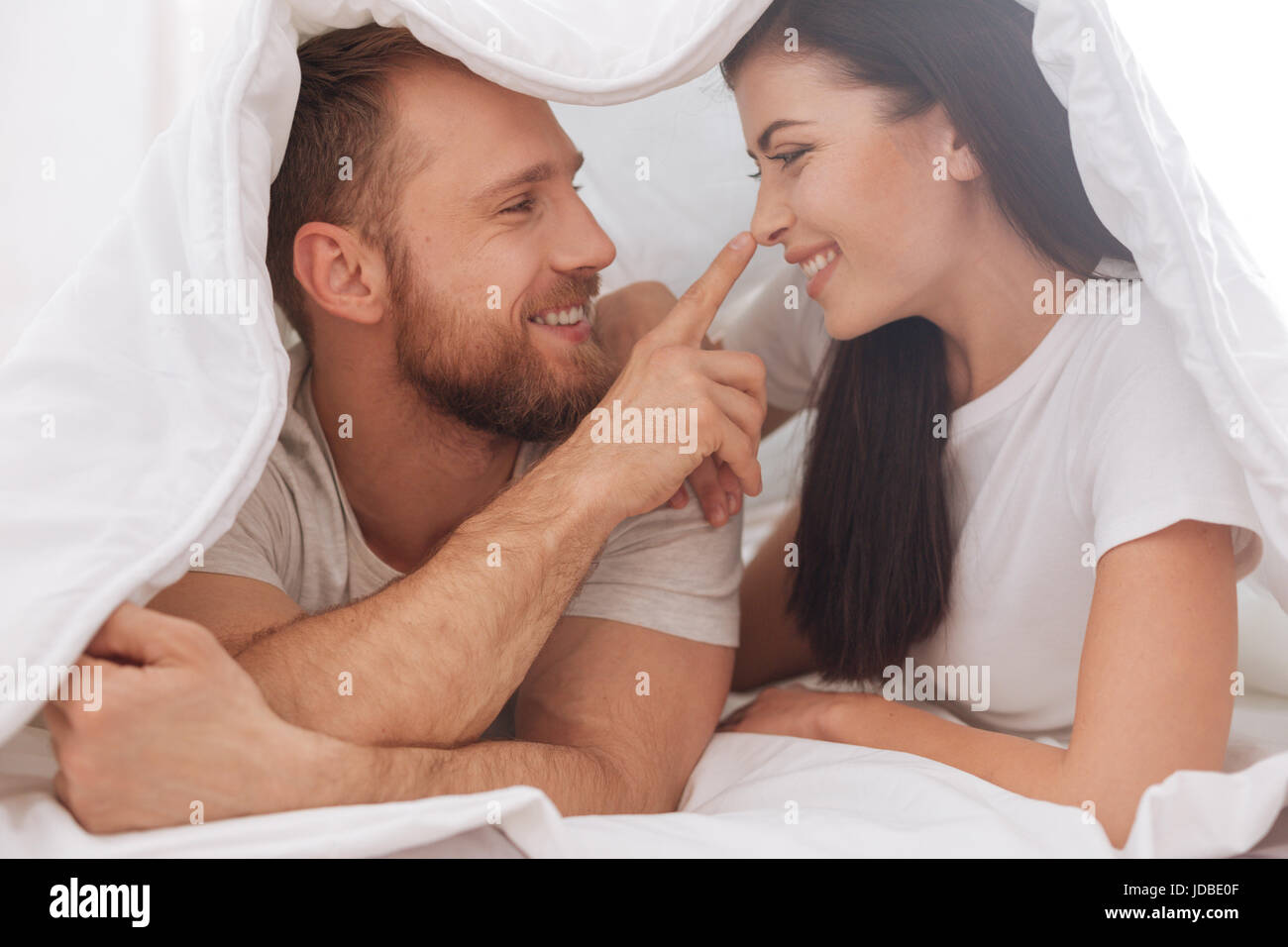 Cheerful man touching his wife nose Stock Photo - Alamy