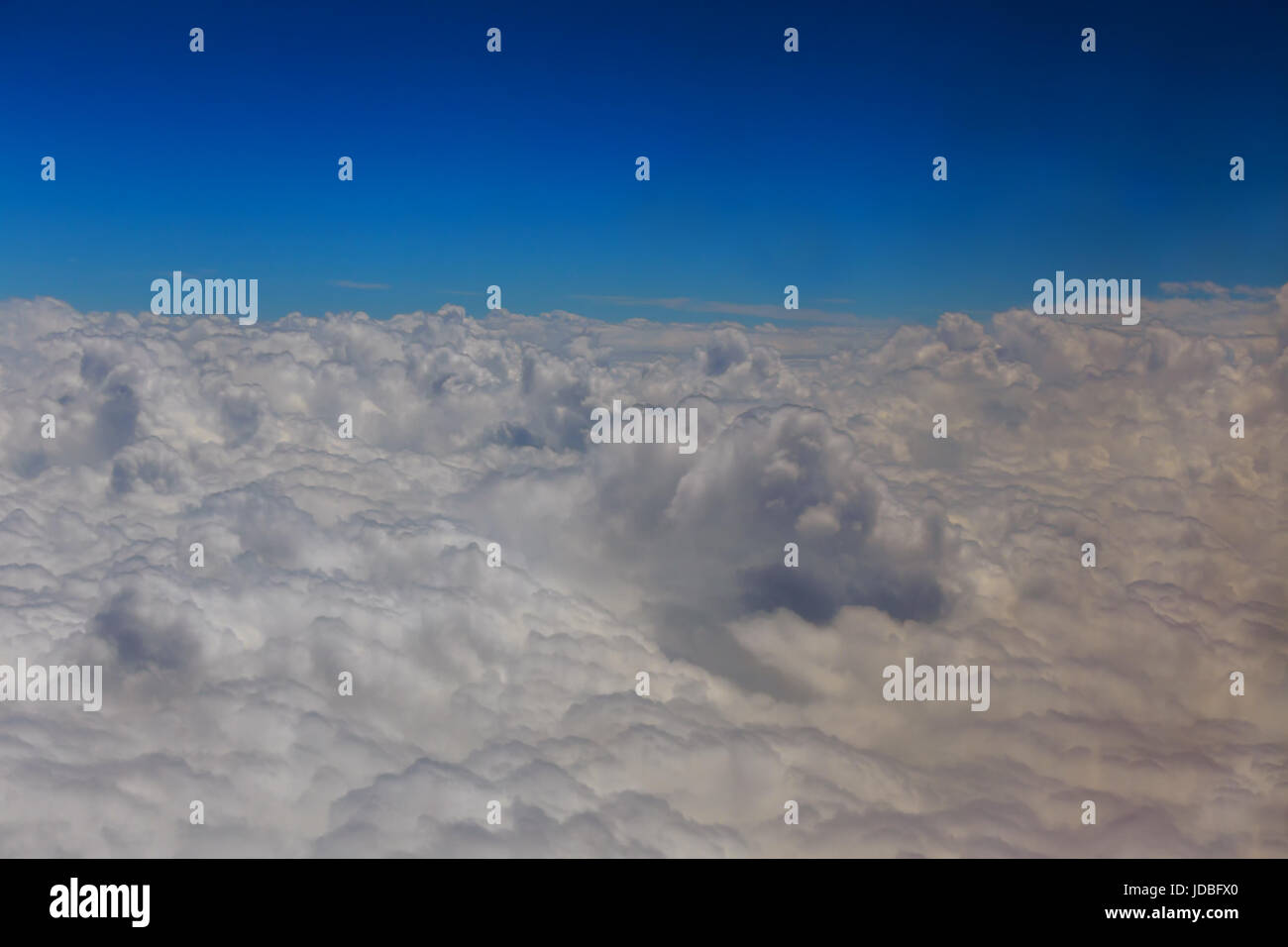 View from above the clouds with an airplane passing by Stock Photo - Alamy