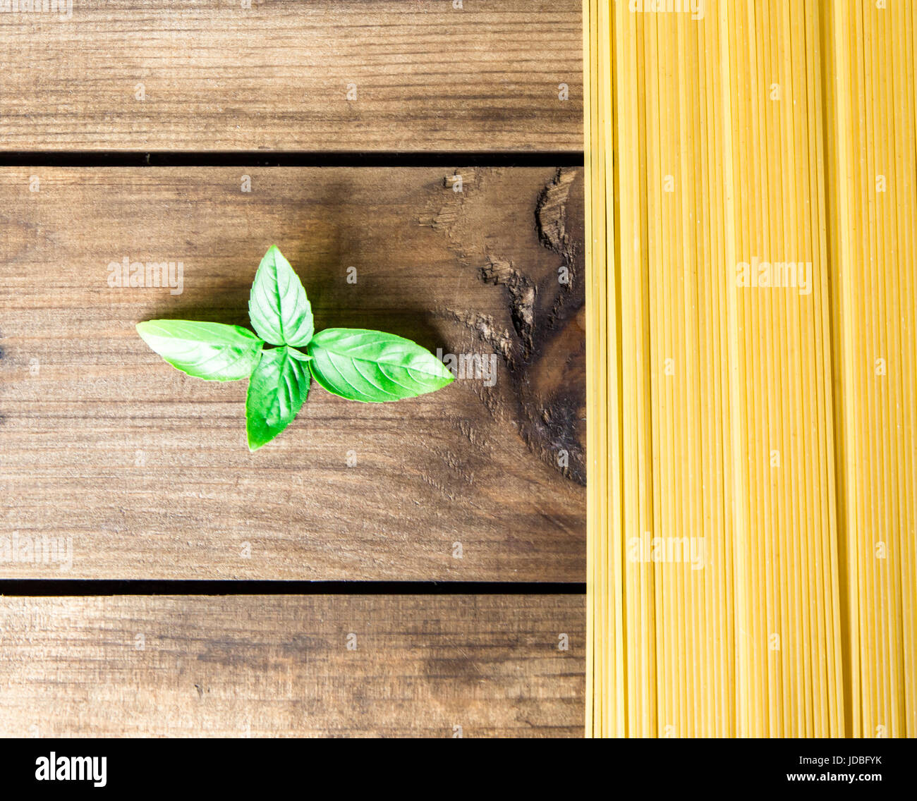 background with Bunch of spaghetti on wooden table with basil Stock ...