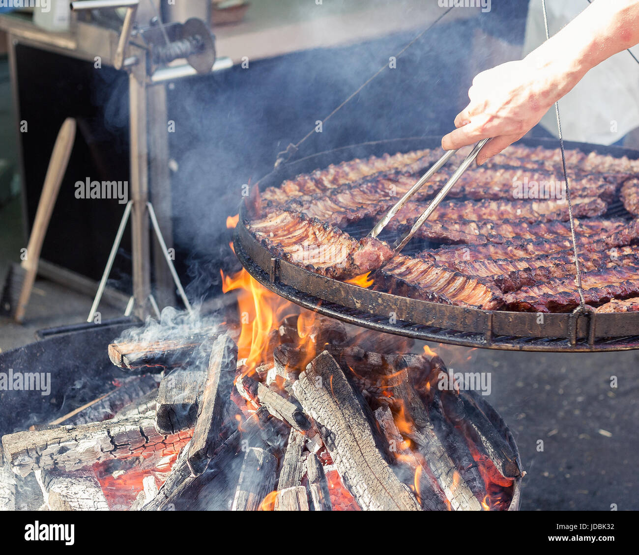 Cooking meat on the big flaming BBQ grill at street food market Stock ...