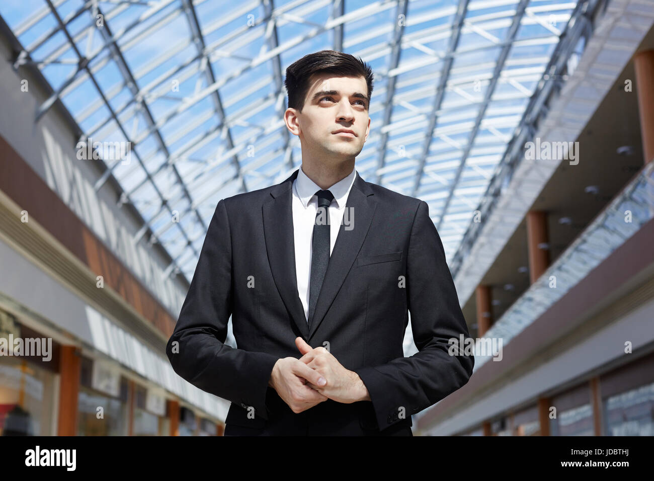 Low angle portrait of successful businessman standing confidently ...