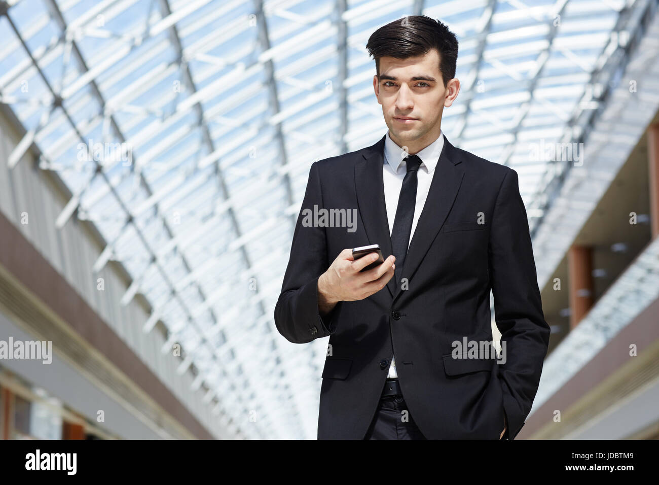 Portrait of confident successful businessman holding smartphone and ...