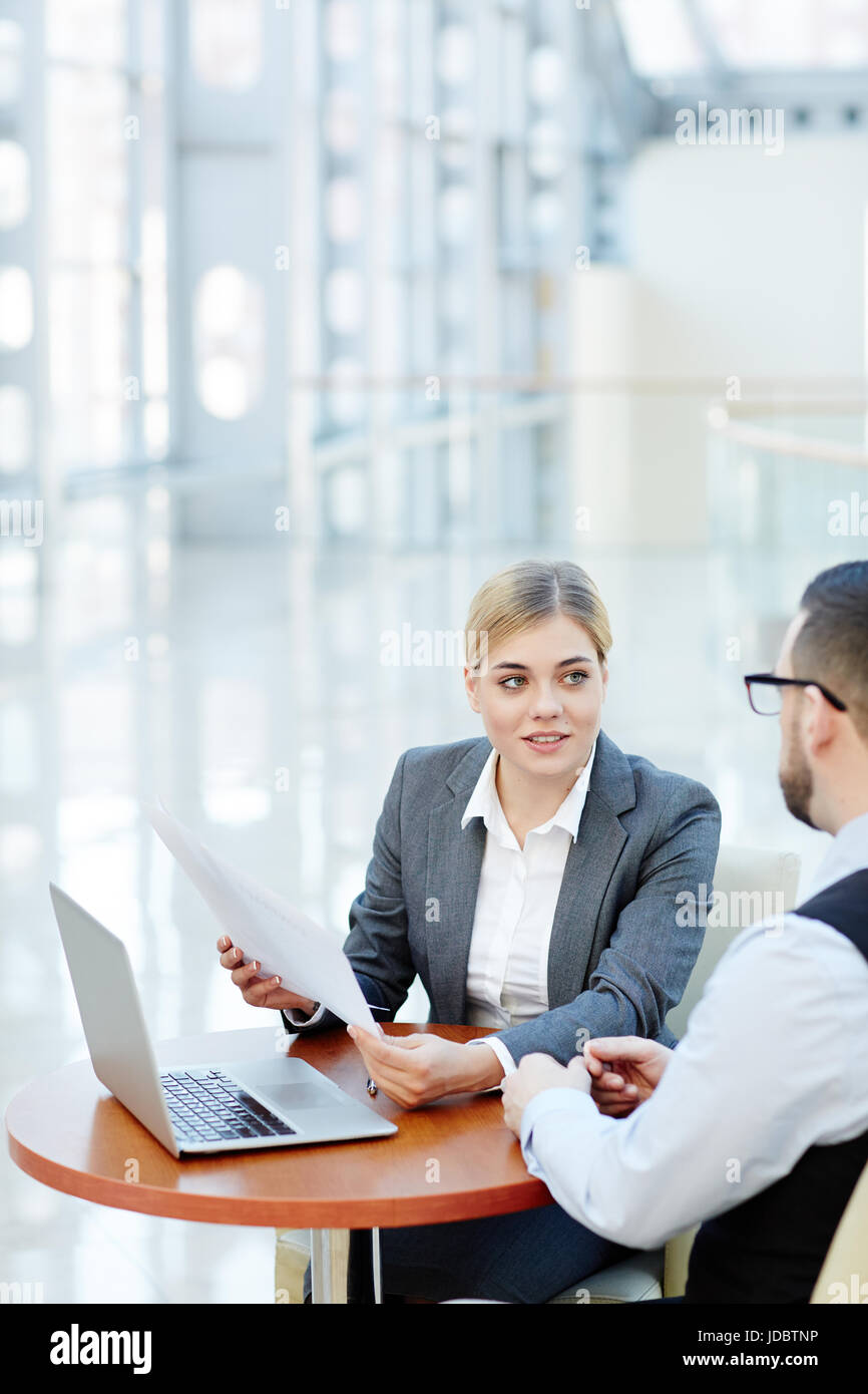 Portrait of young businesswoman consulting client on bank products ...