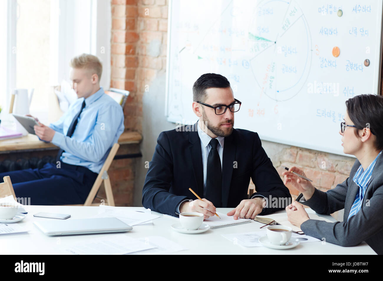 Serious boss listening to idea of employee Stock Photo - Alamy
