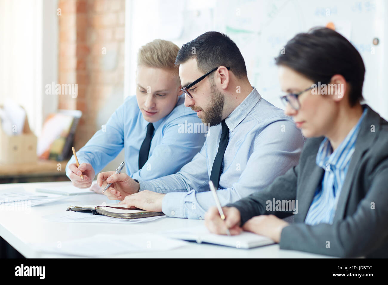 Brainstorming business professionals writing hi-res stock photography ...