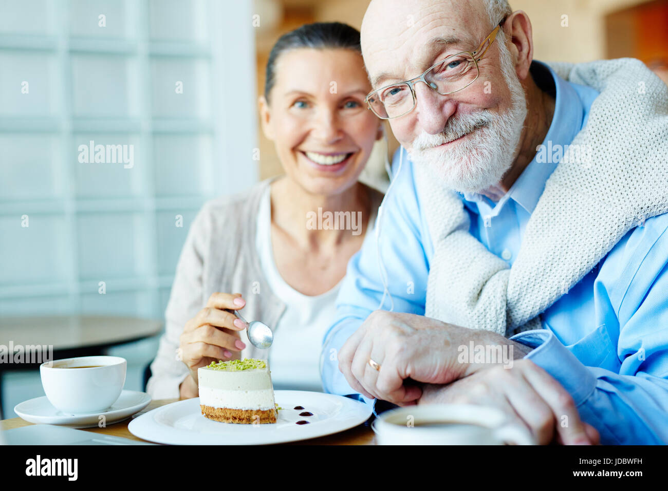 Happy senior man and his wife eating dessert in cafe Stock Photo - Alamy