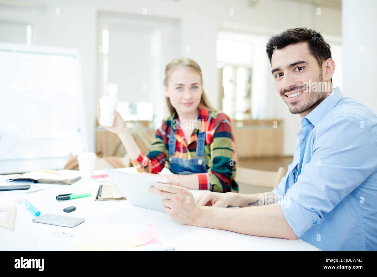 Two groupmates sitting by desk at lesson Stock Photo - Alamy