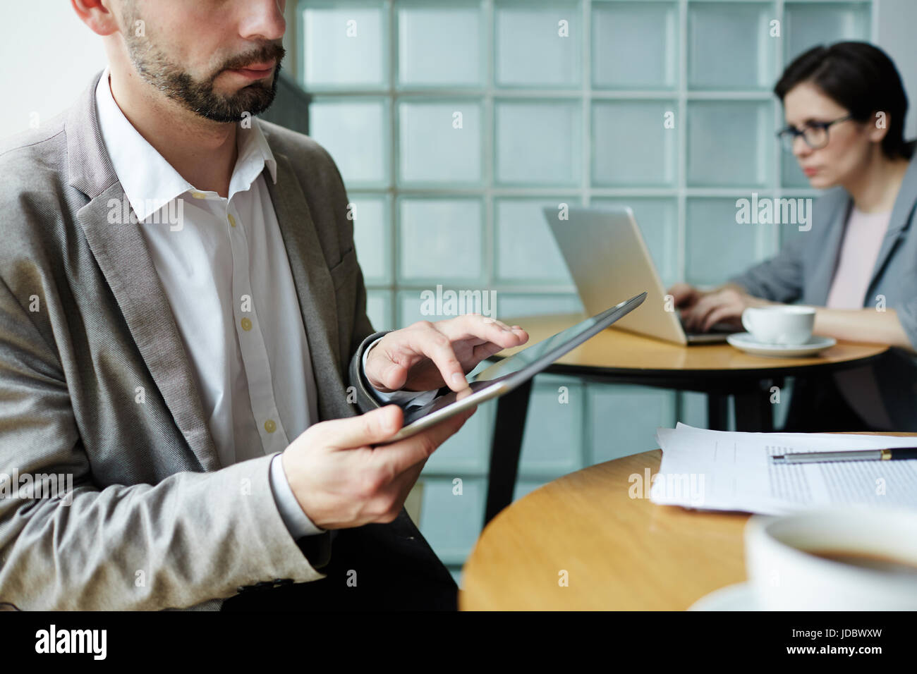 Closeup portrait of business people working at separate tables in co ...