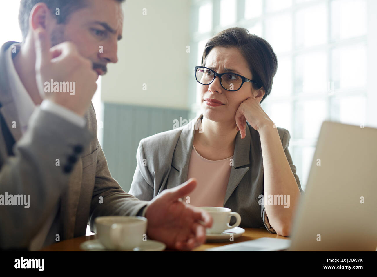 Portrait of two confused business people, man and woman, solving work ...