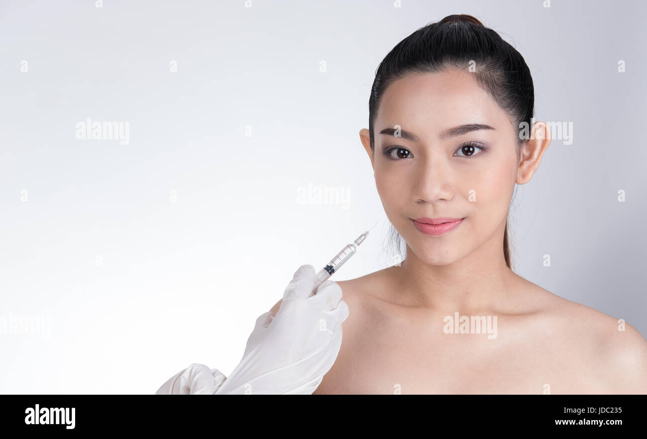 Doctor's hand making a botox injection in girl's face. young asian ...