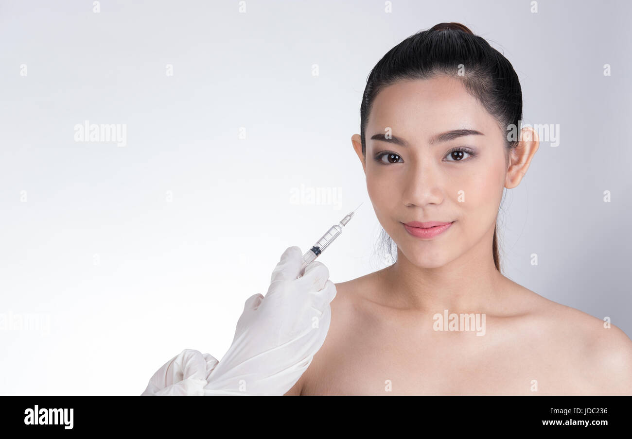 Doctor's hand making a botox injection in girl's face. young asian ...