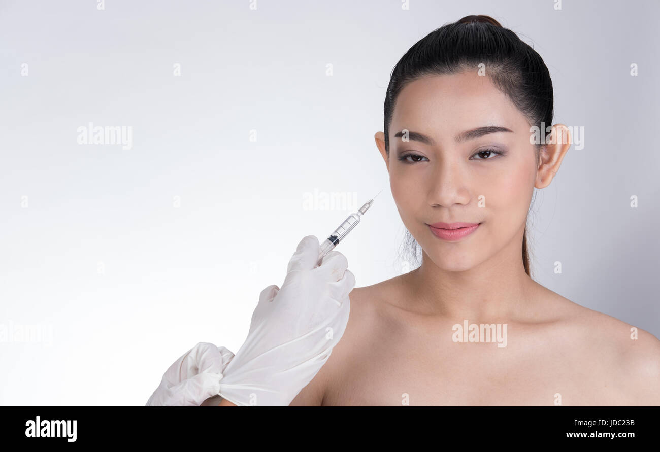 Doctor's hand making a botox injection in girl's face. young asian ...