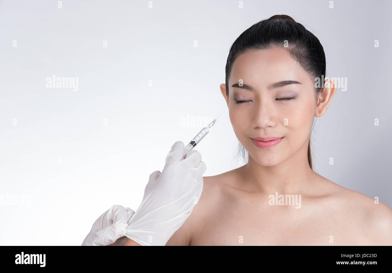Doctor's hand making a botox injection in girl's face. young asian ...