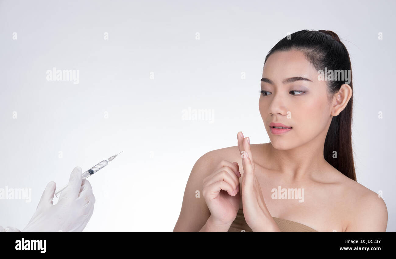 Attractive woman scared of injection. Girl looking with fear at a ...