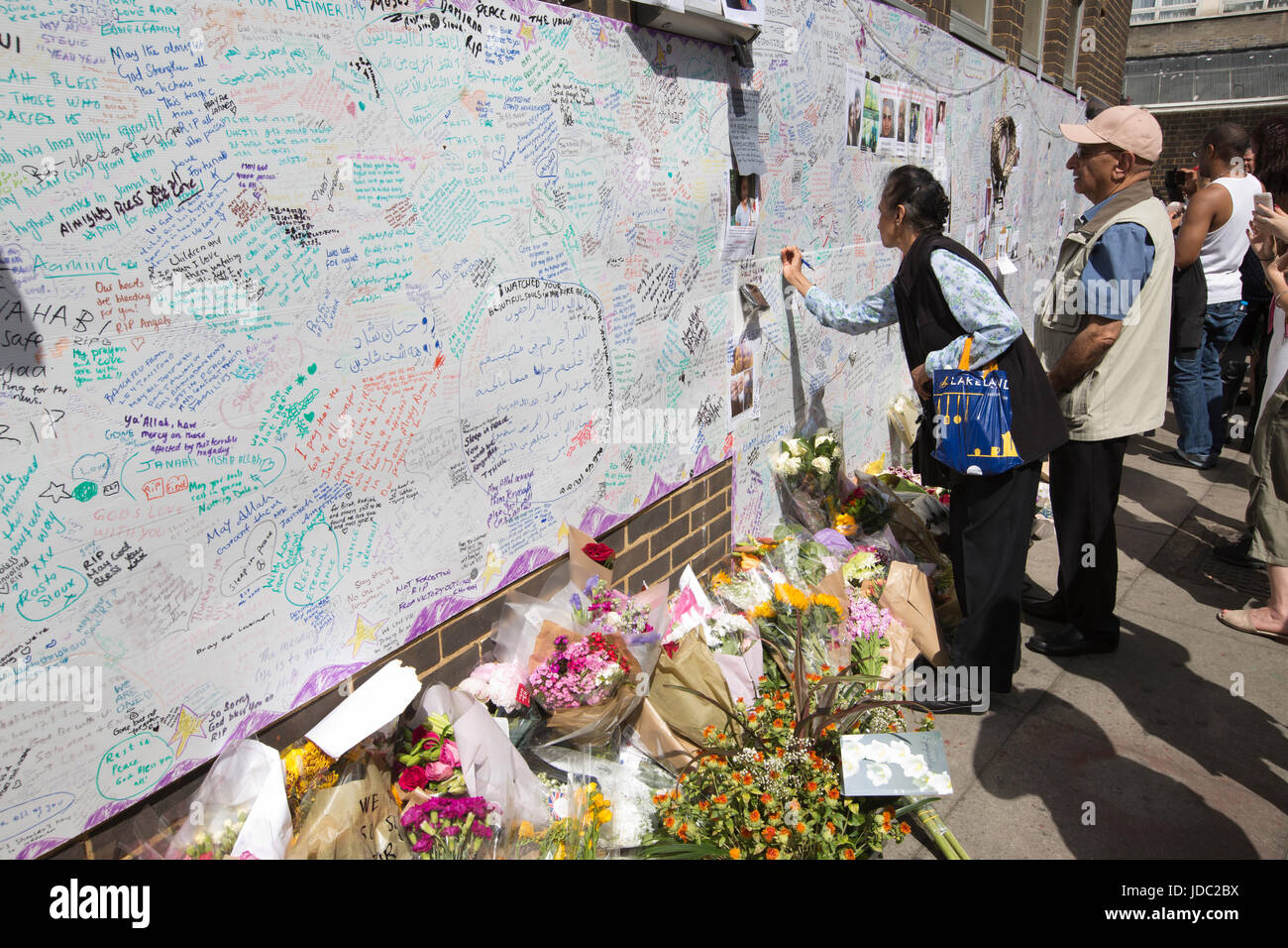People leave tributes on a wall off condolence to the victims who died ...