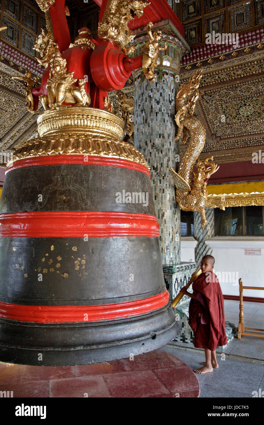 Buddhist boy hitting the great Singu Min bell located in the Shwedagon ...