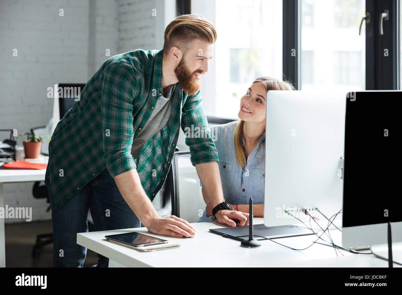 Photo of two young concentrated colleagues work in office using ...