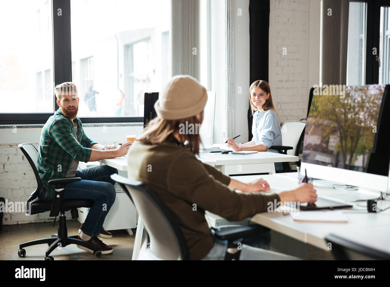 Picture of young colleagues work in office using computers. Looking ...