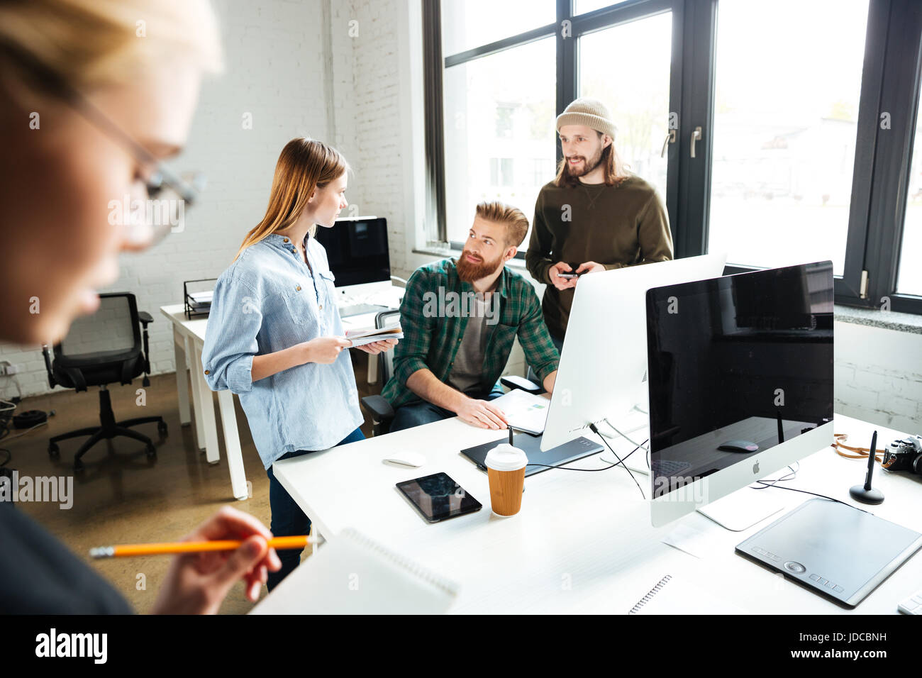 Image of young concentrated colleagues in office using computer ...