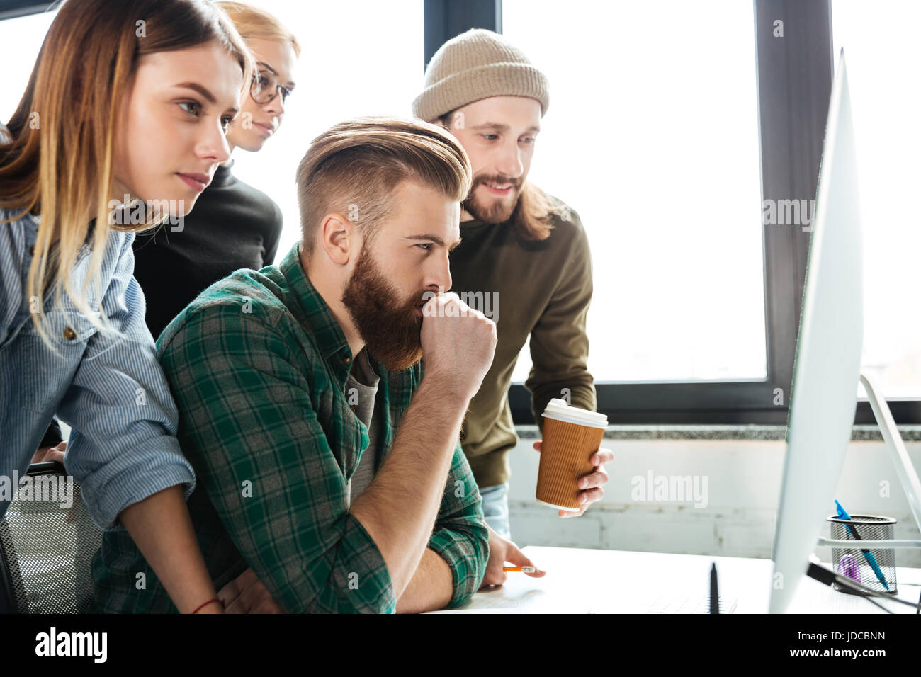 Image of young concentrated colleagues in office using computer ...