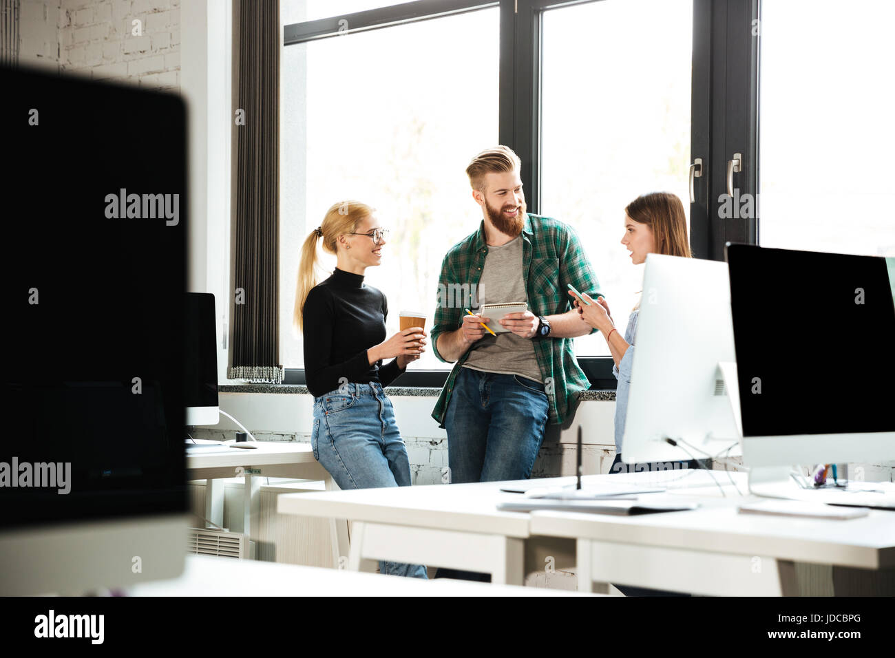 Image of young concentrated colleagues in office talking with each ...